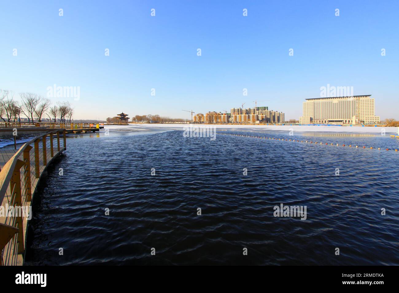 building and trestle bridge in river edge, in the winter, North China ...