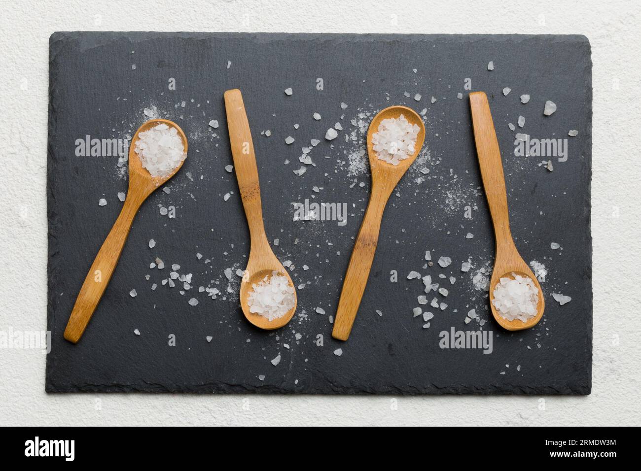 salt on many wooden spoon on wood background. Spoons with different ...