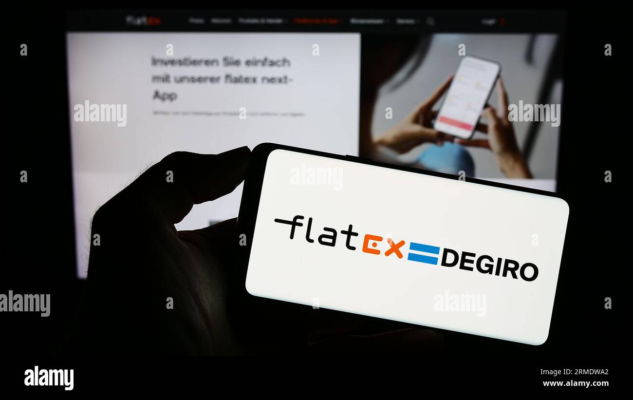 Person holding mobile phone with logo of German fintech company Flatexdegiro AG on screen in ...