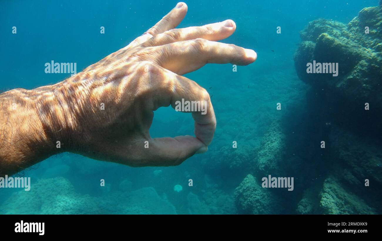 ok sign human hand underwater detail close up Stock Photo - Alamy