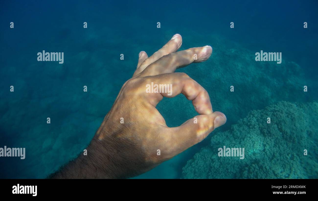ok sign human hand underwater detail close up Stock Photo - Alamy