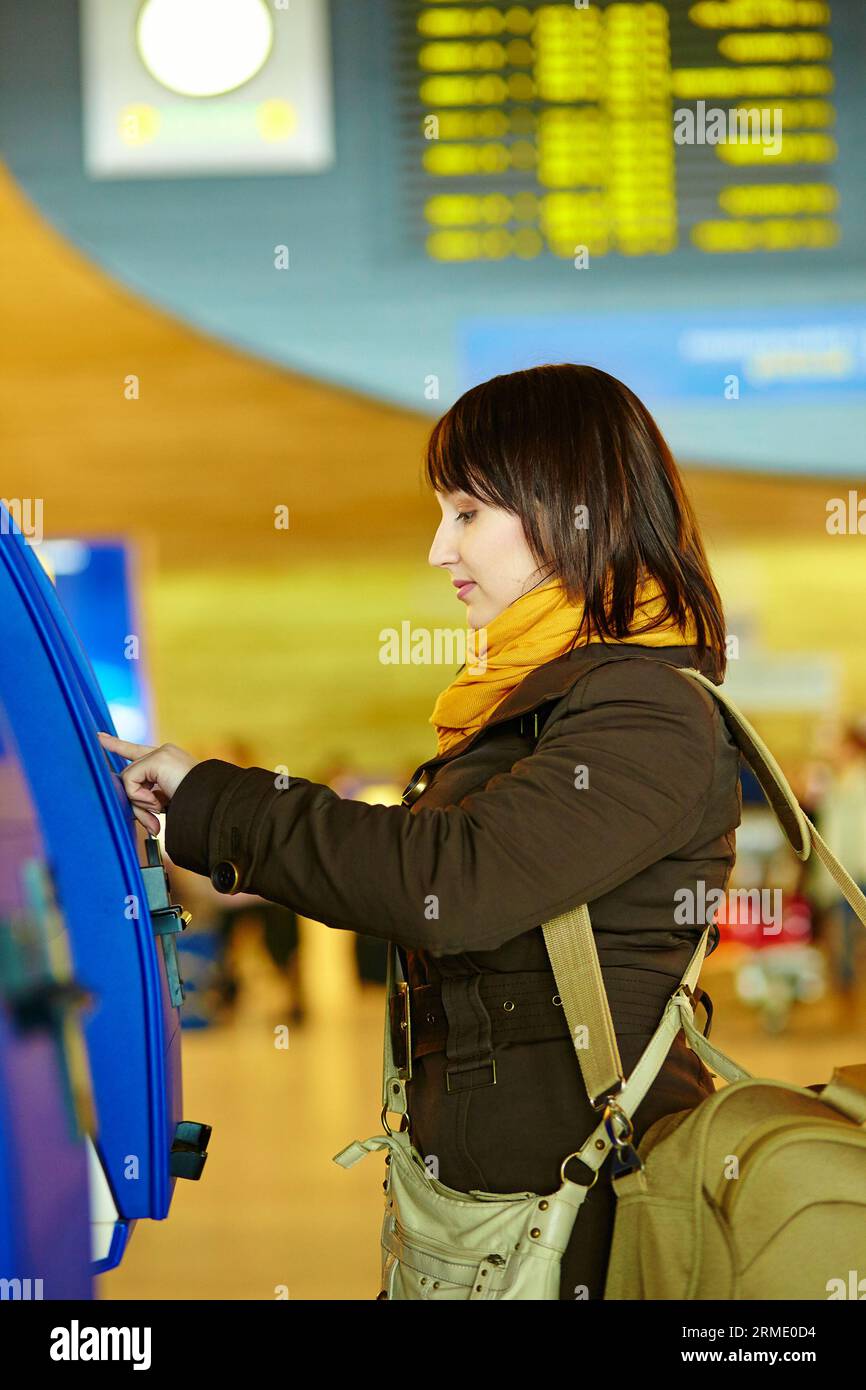 Girl doing self-checkin in the airport before taking her flight Stock ...