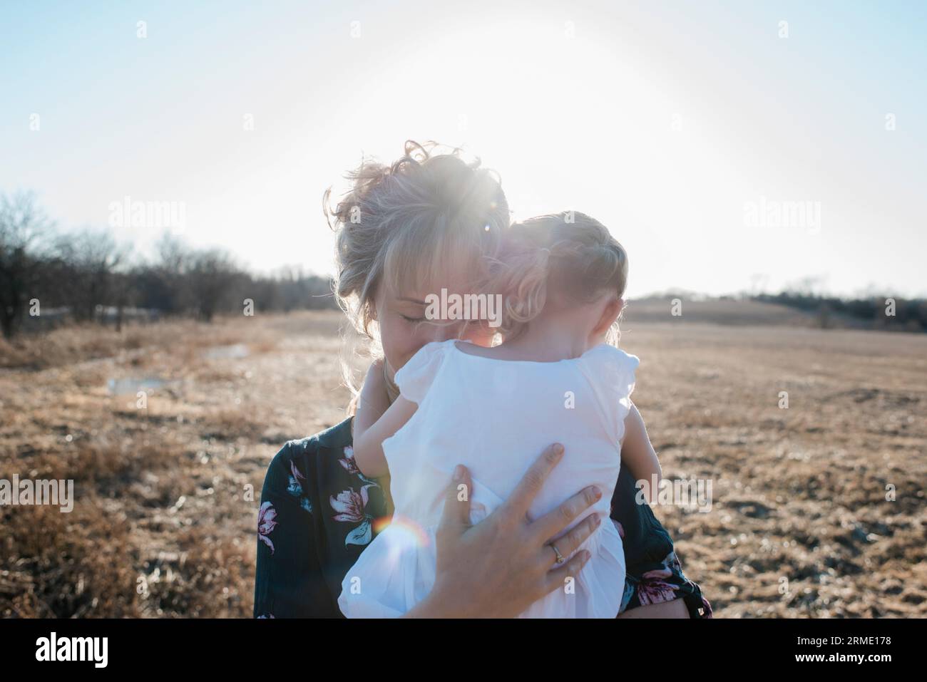 mother and daughter cuddling outside at sunset Stock Photo - Alamy