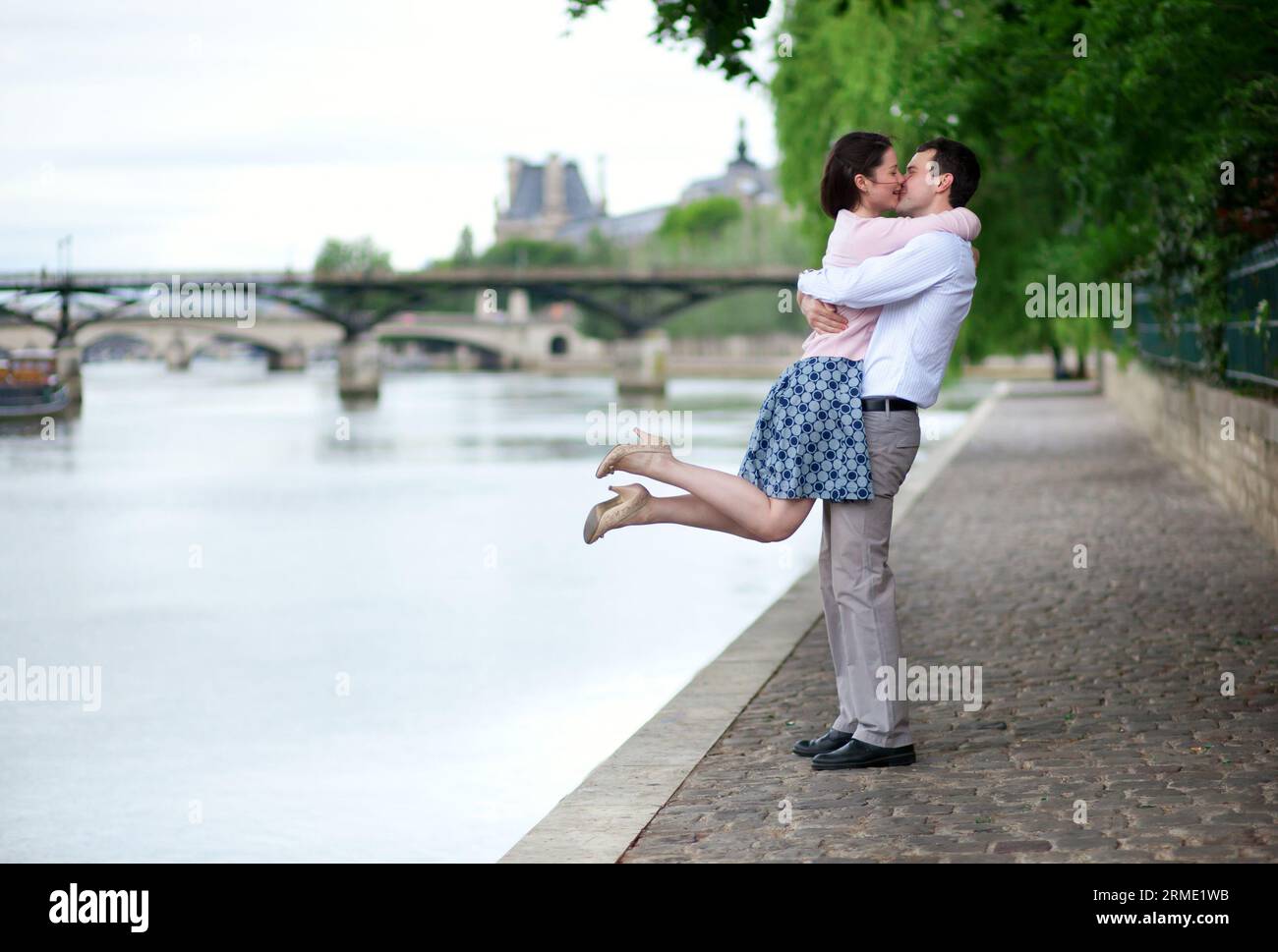 Happy romantic couple is hugging near the Seine, girl is jumping Stock ...