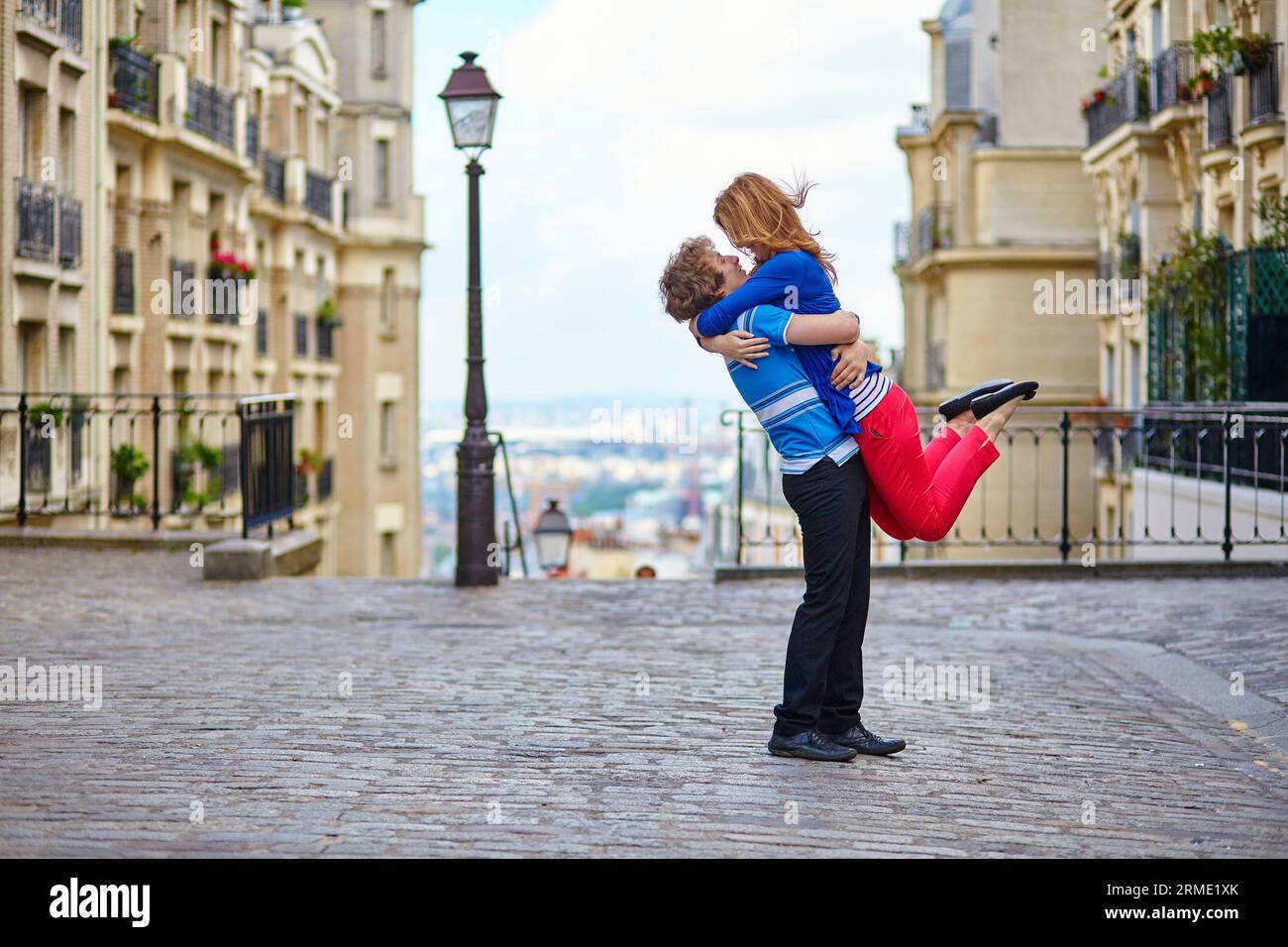 Young dating couple hugging on Montmartre, girl is jumping Stock Photo ...
