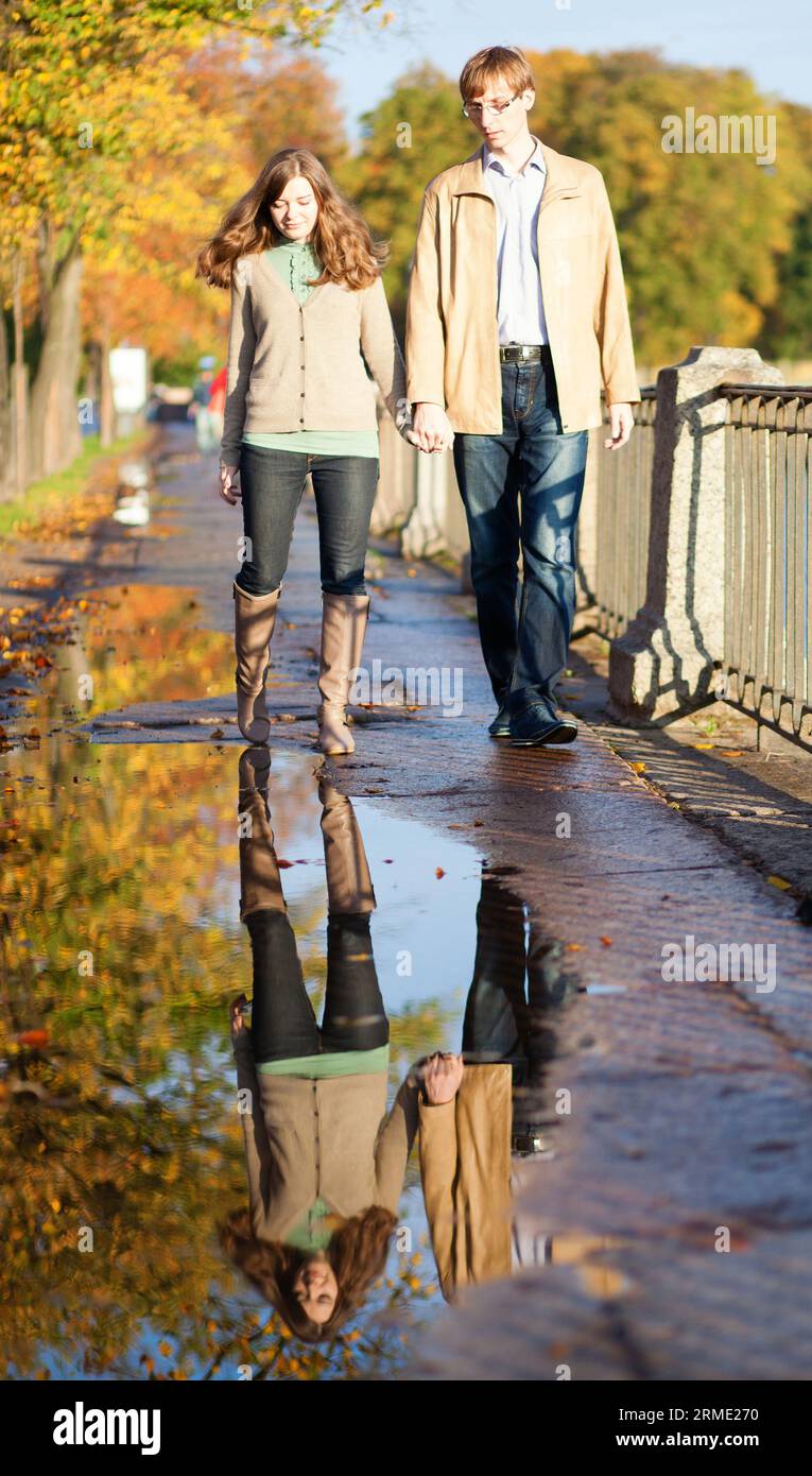 Dating couple and their reflection in a puddle Stock Photo - Alamy