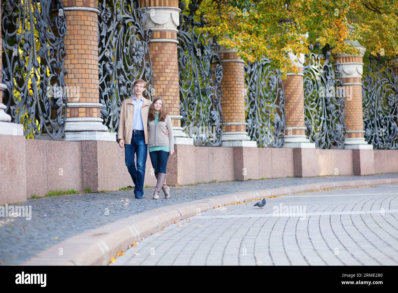 Couple walking by the beautiful grill of Mikhailovsky (Michael) garden ...