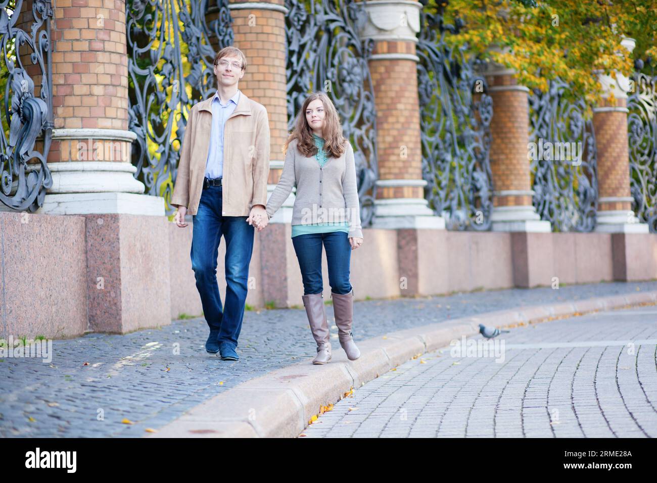 Couple walking by the beautiful grill of Mikhailovsky (Michael) garden ...