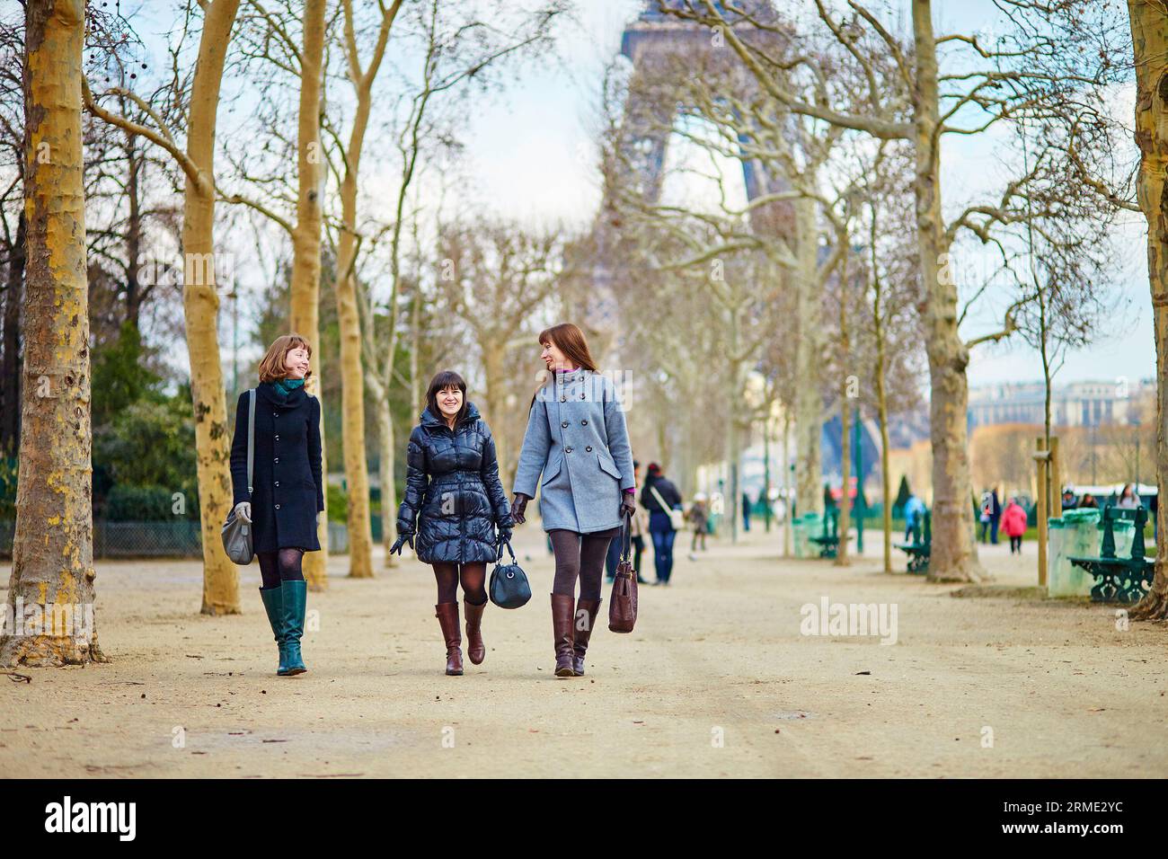 Three girls posing near the Eiffel tower Stock Photo - Alamy