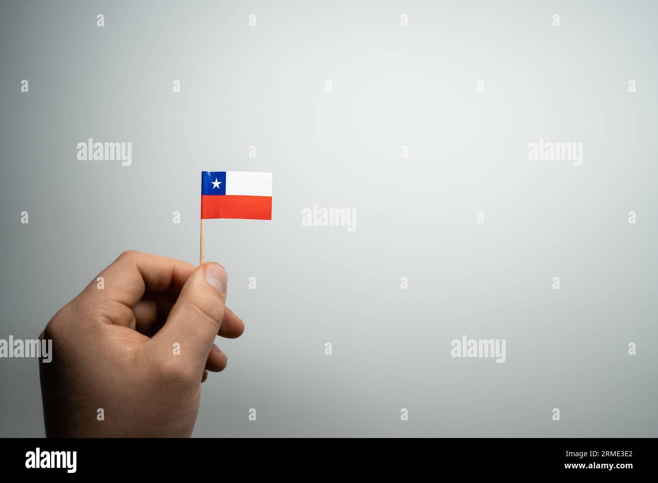 hand holding a chilean flag with white background Stock Photo - Alamy