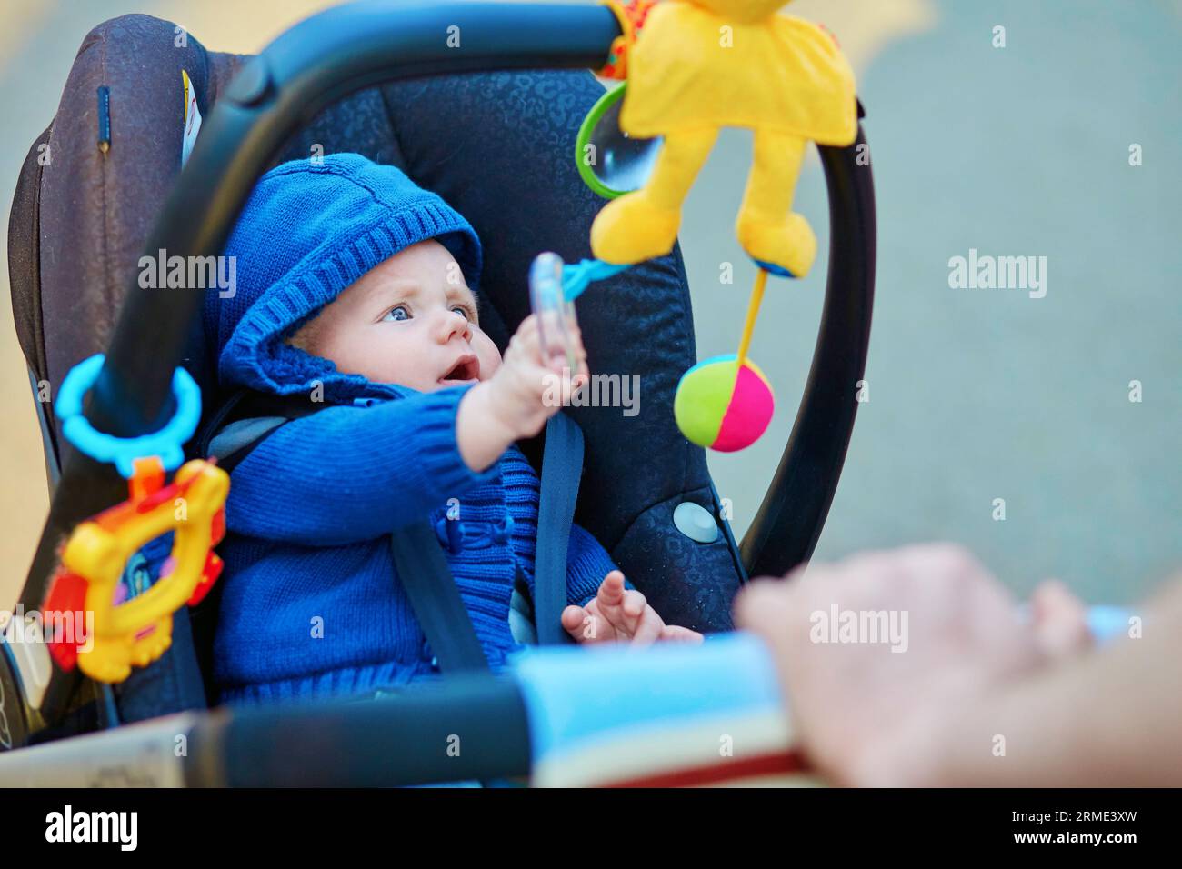 Little baby boy in stroller playing with toys Stock Photo - Alamy