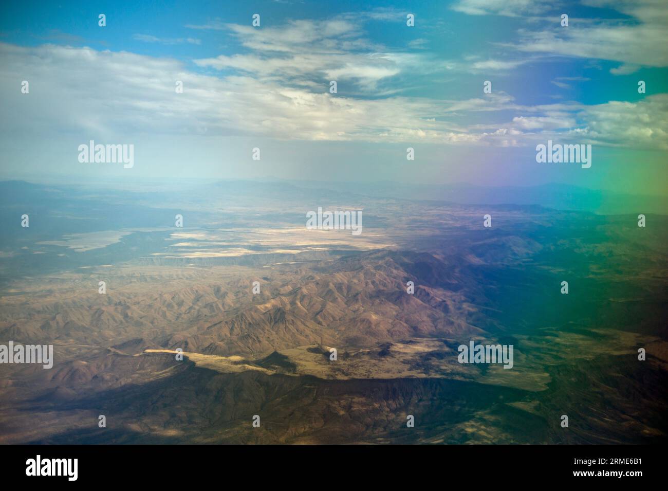 Rugged western landscape with rainbow from airplane window Stock Photo ...