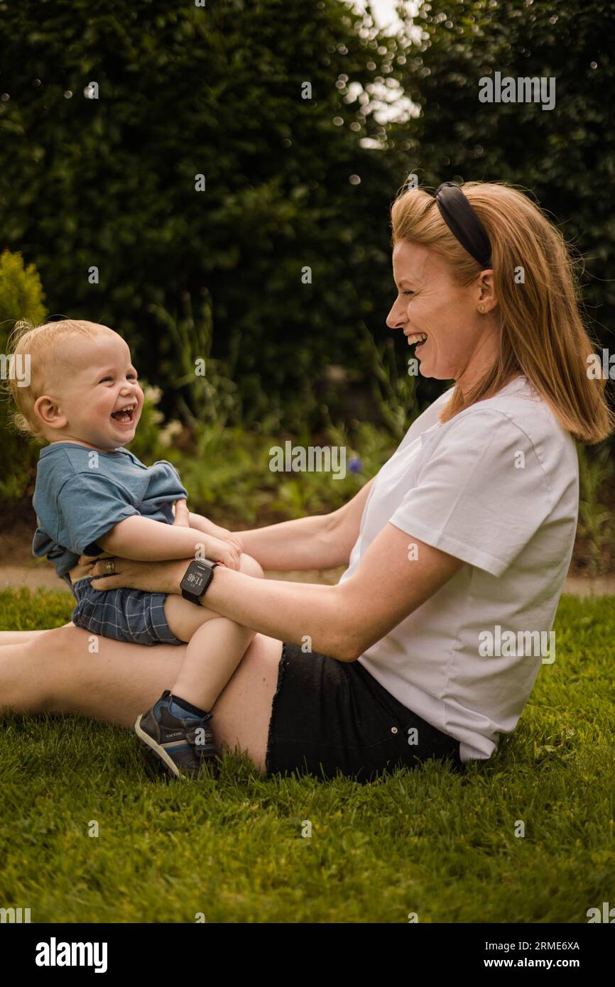 Mother and toddler share laughter while playing in the garden Stock ...