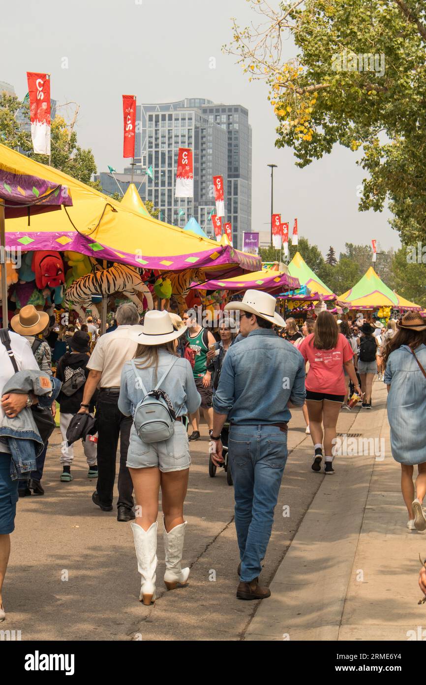 Western couple walks through a vibrant crowd at a cowboy festival Stock ...