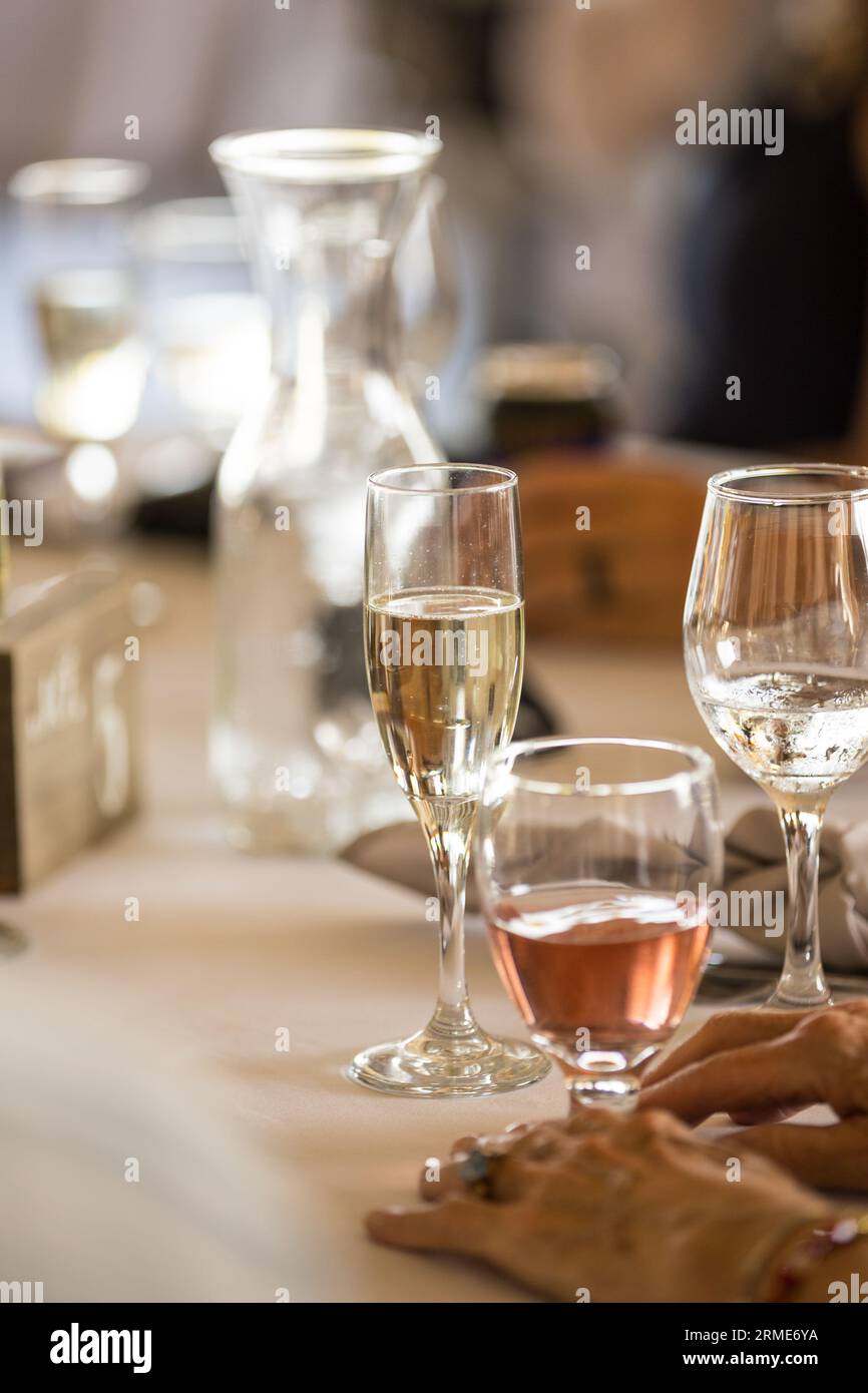 Champagne glass amidst lively tables at summer wedding Stock Photo - Alamy
