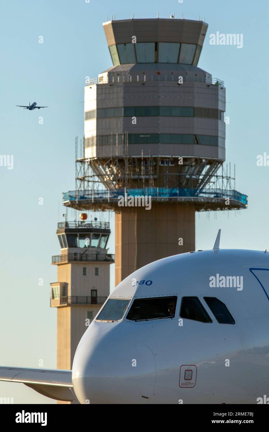 Plane taking off past tower second plane in foreground Stock Photo - Alamy