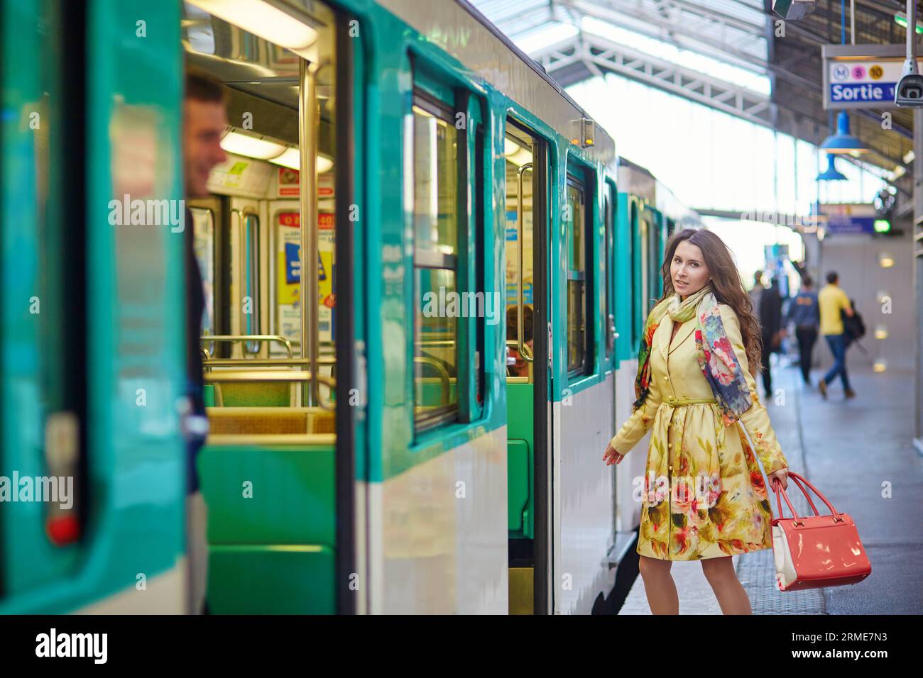 Beautiful young woman running to catch a train on the platform of ...