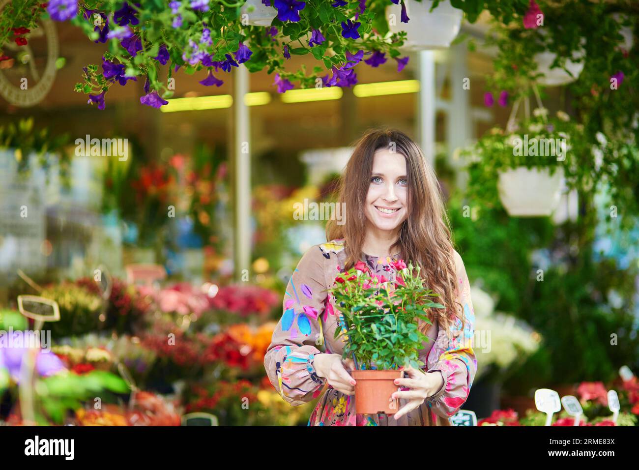 Beautiful young customer selecting fresh flowers in Parisian flower ...