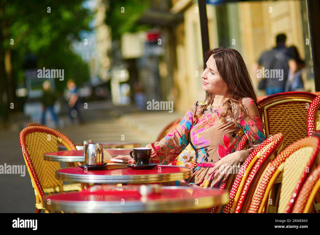 Beautiful young woman in a Parisian street cafe, enjyoing sunny week ...