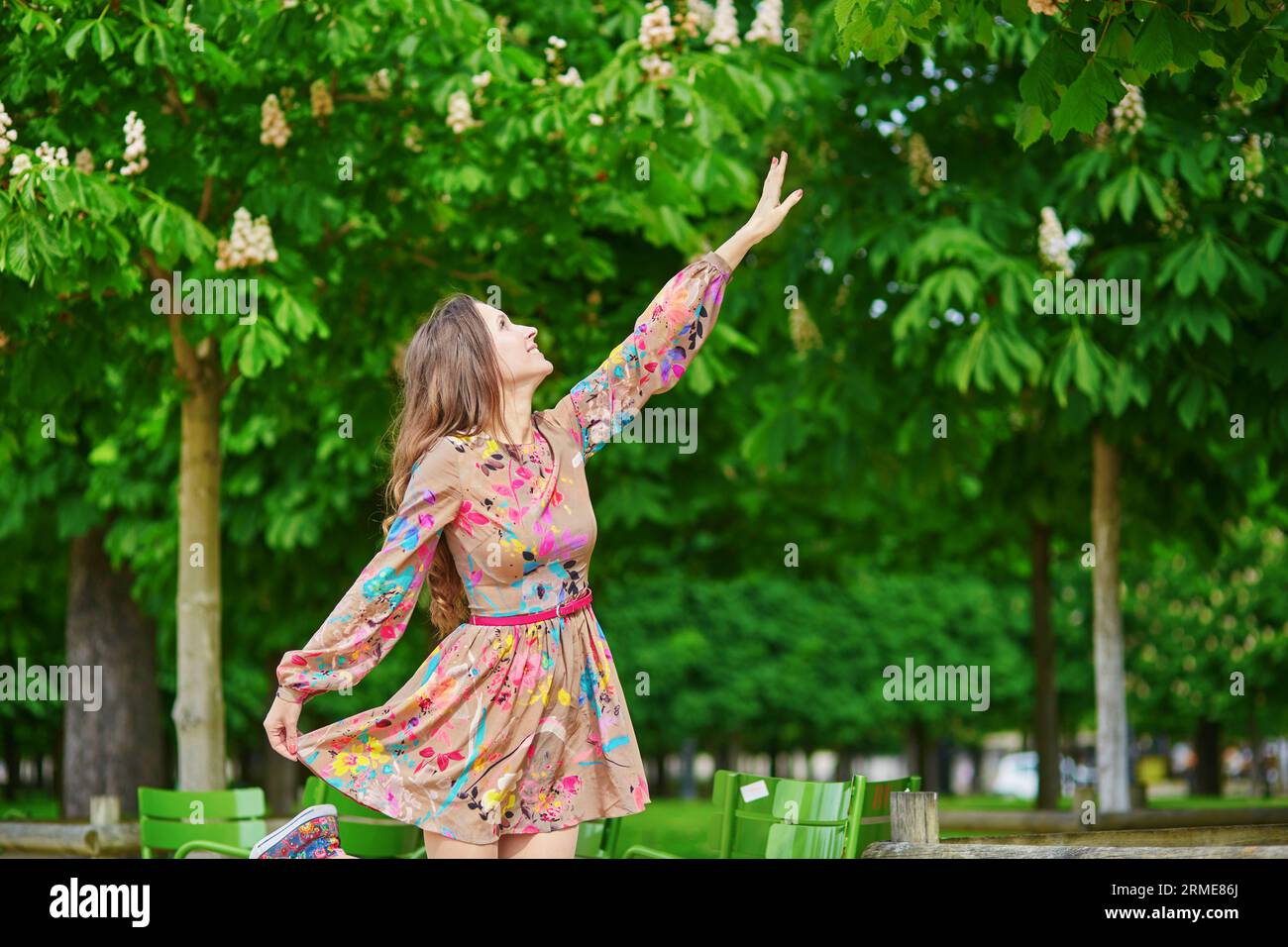 Beautiful young woman in the Tuileries garden, walking under chestnut ...