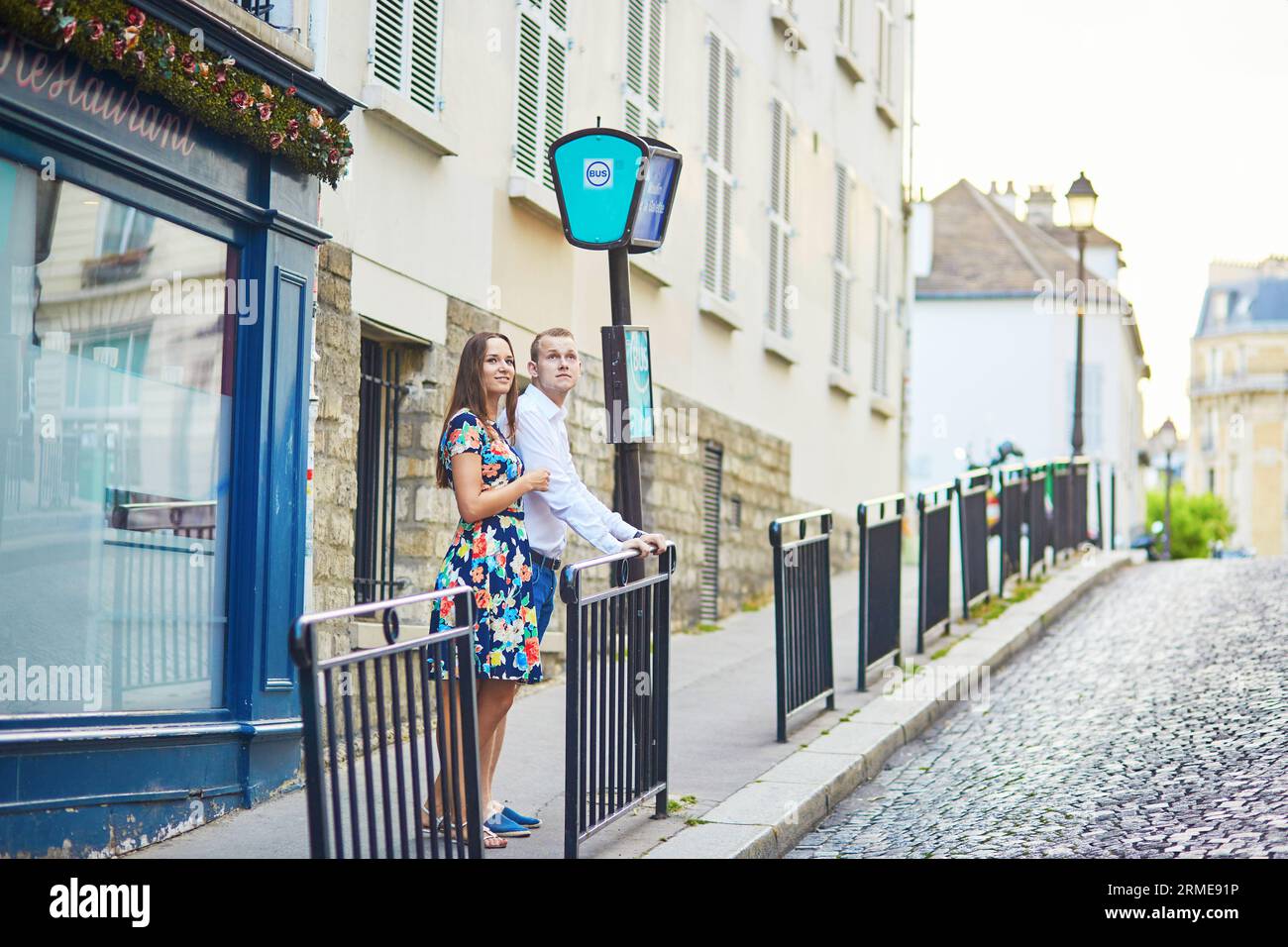 Young romantic couple waiting for a bus on a busstop on Montmartre in ...