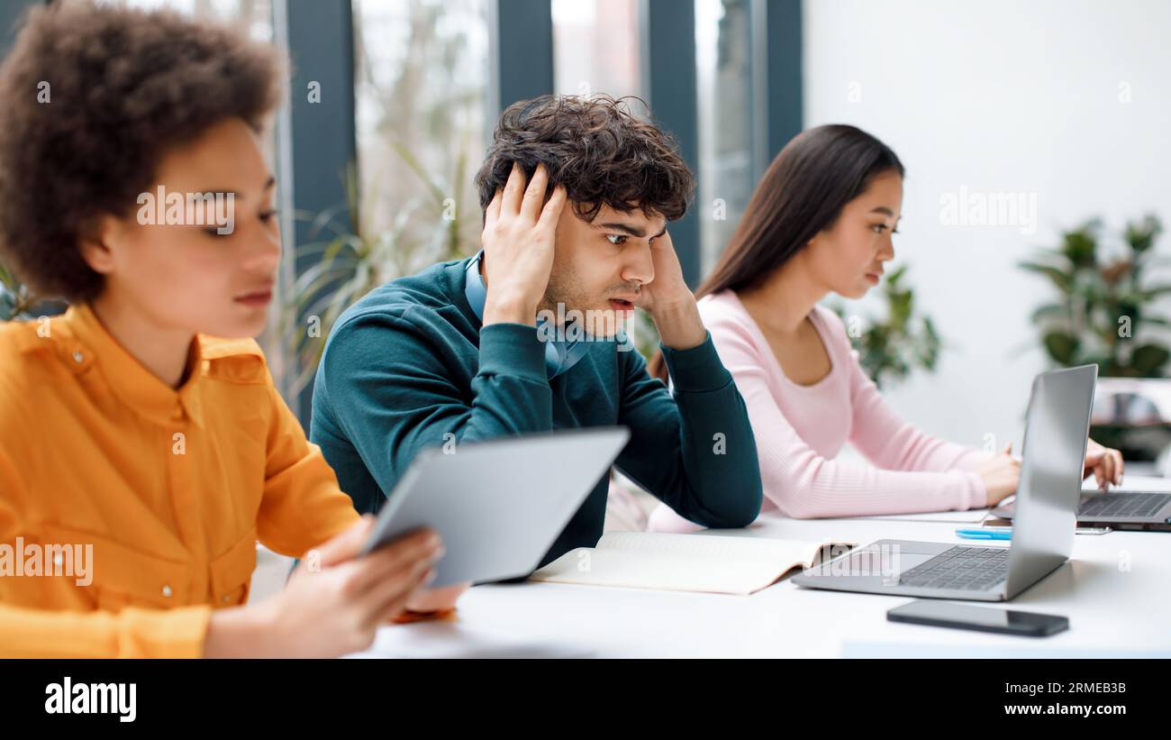 Worried sad student guy looking at laptop, getting final test results ...