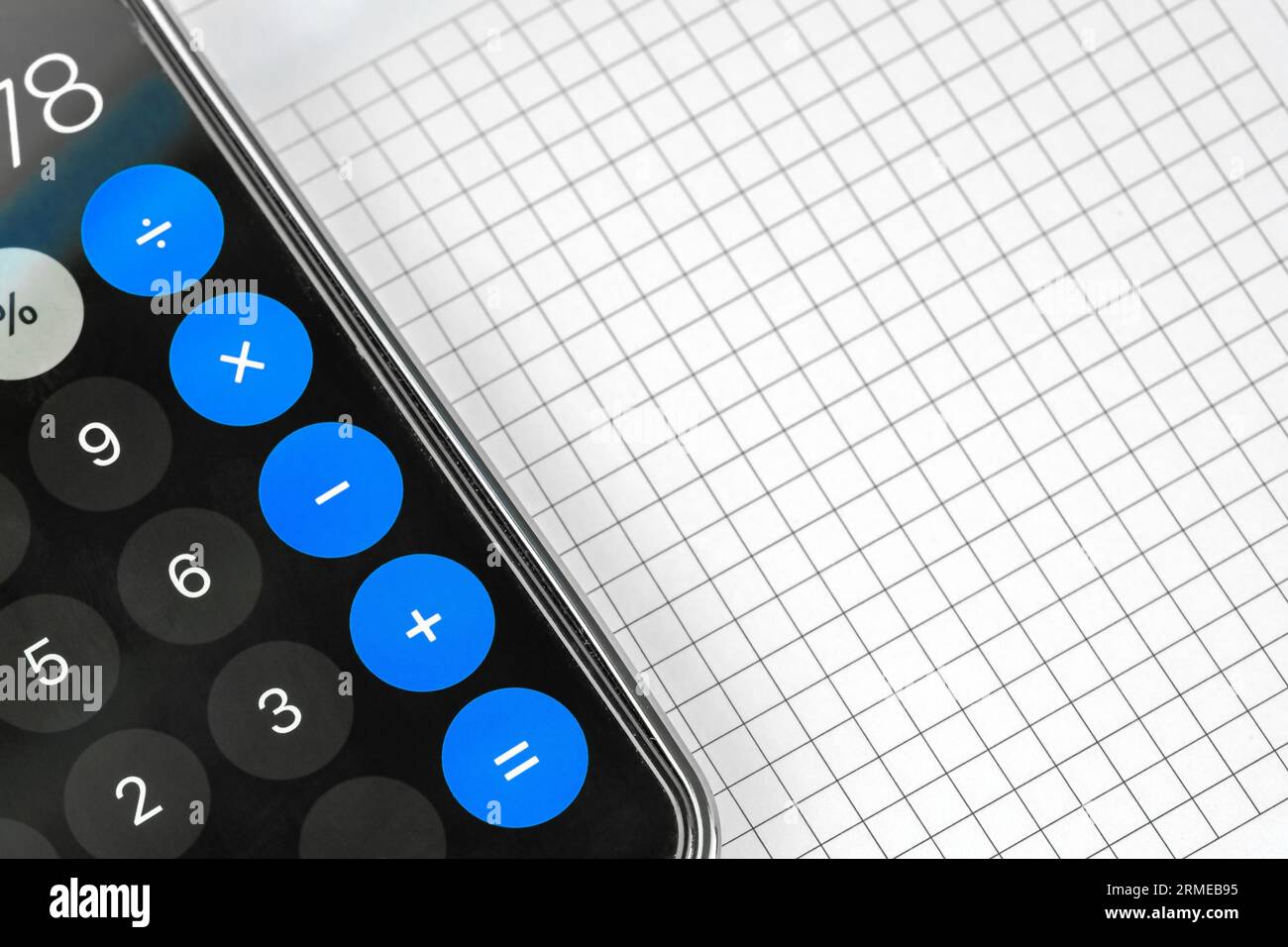 Calculator lying on blank sheet of maths paper closeup. Education ...