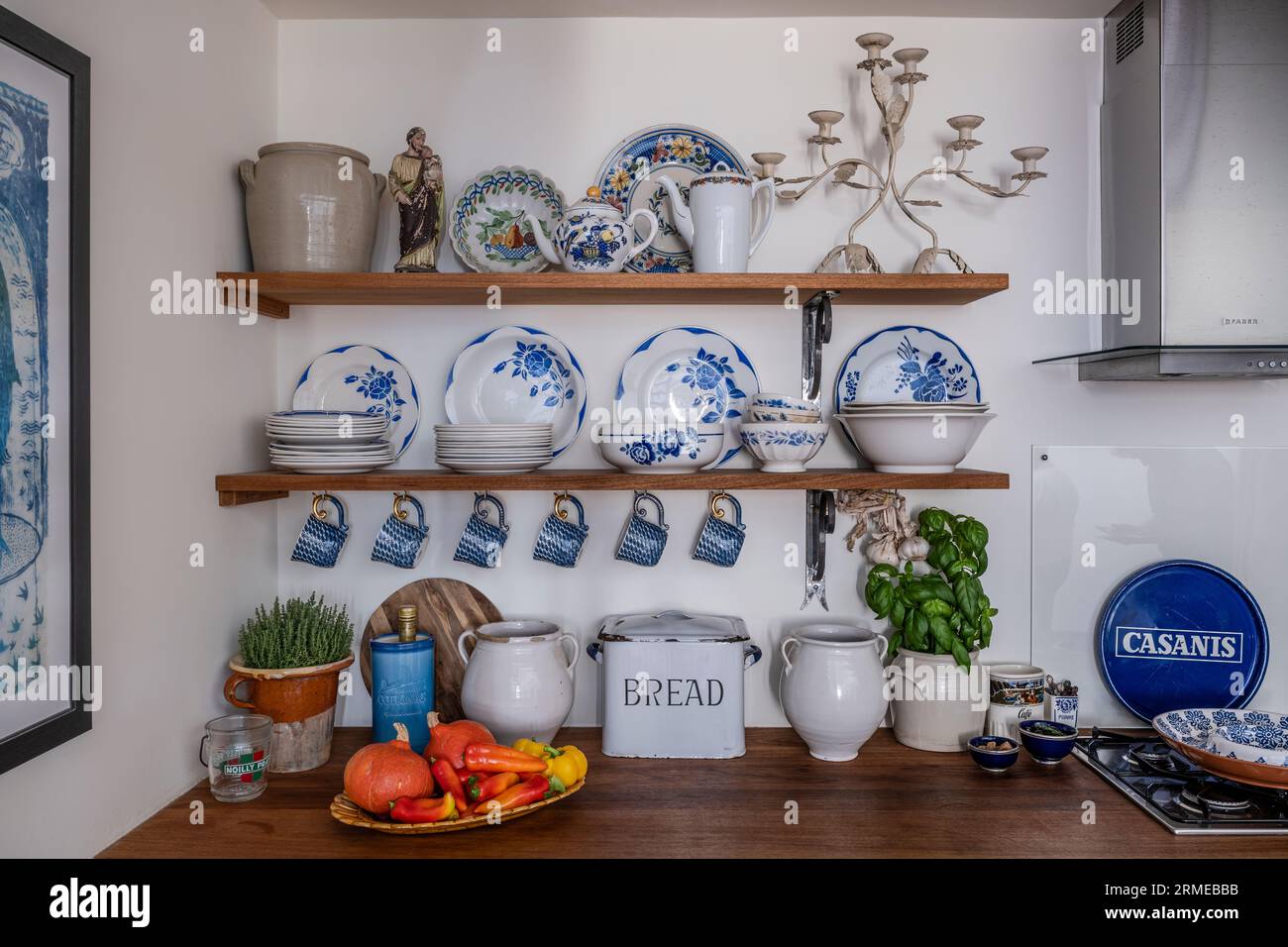 Blue and white stencilled china on open shelves in Cotignac kitchen ...