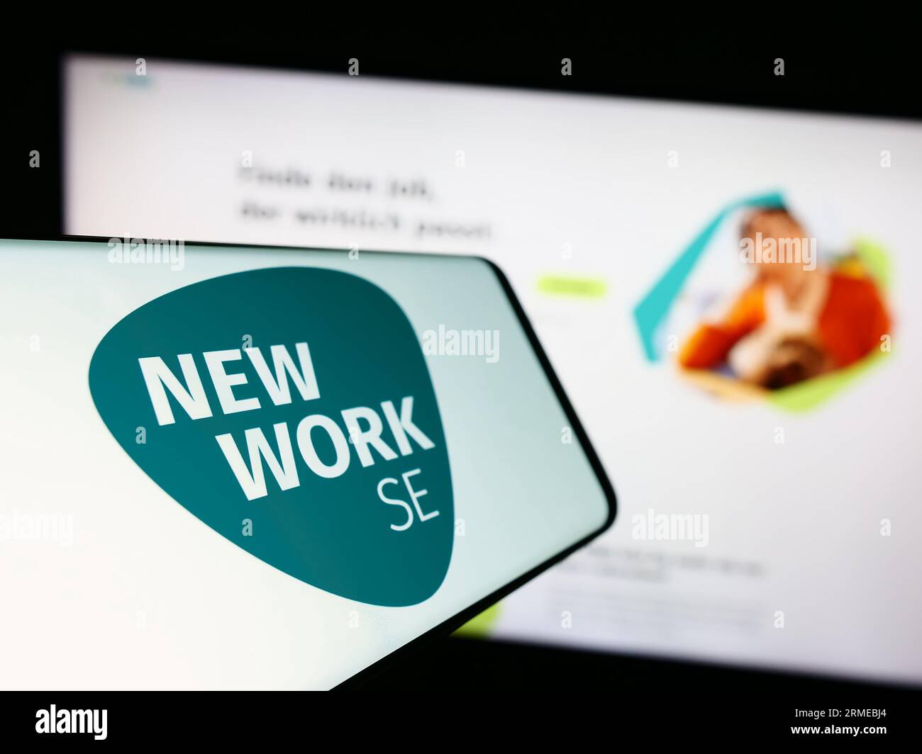 Smartphone with logo of German company New Work SE (XING) on screen in front of business website ...