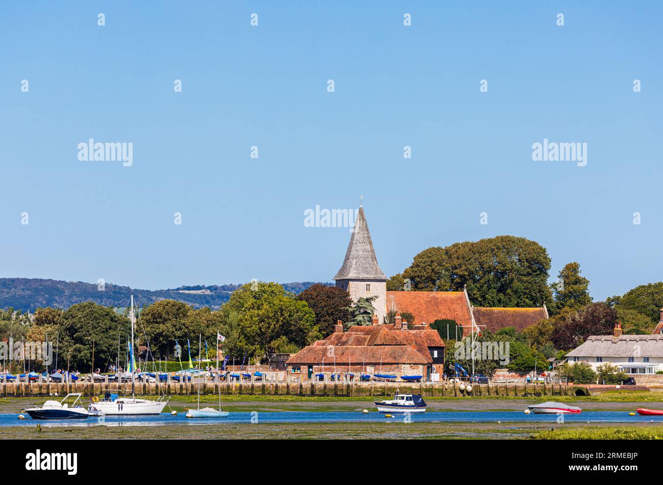 Holy Trinity Church and boats at Bosham Quay in historic Bosham, a ...