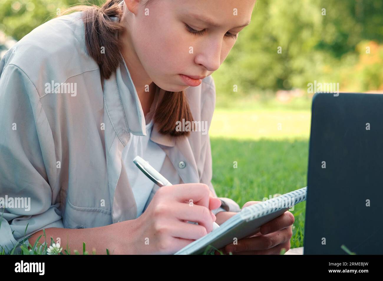 Teenage schoolgirl studying reading her books, tablet and notebook ...