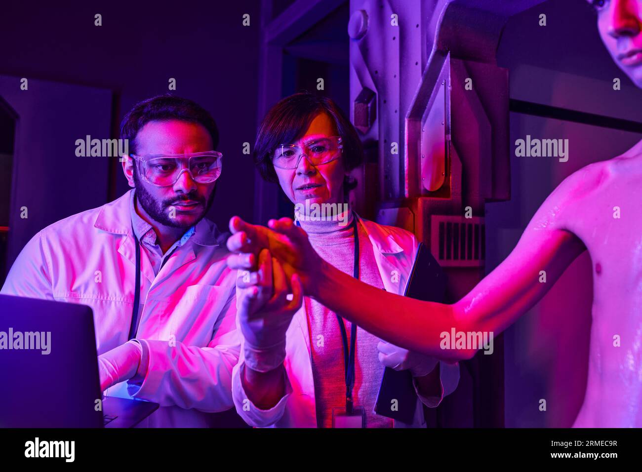 indian scientist with laptop near colleague holding hand of cosmic ...