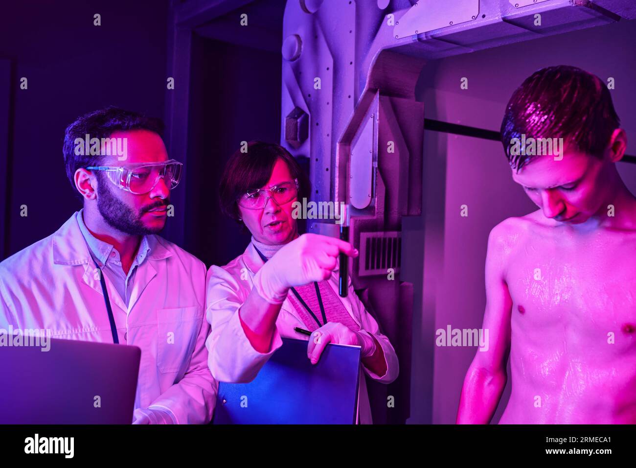 multiethnic scientists looking at test tube with blood sample near ...