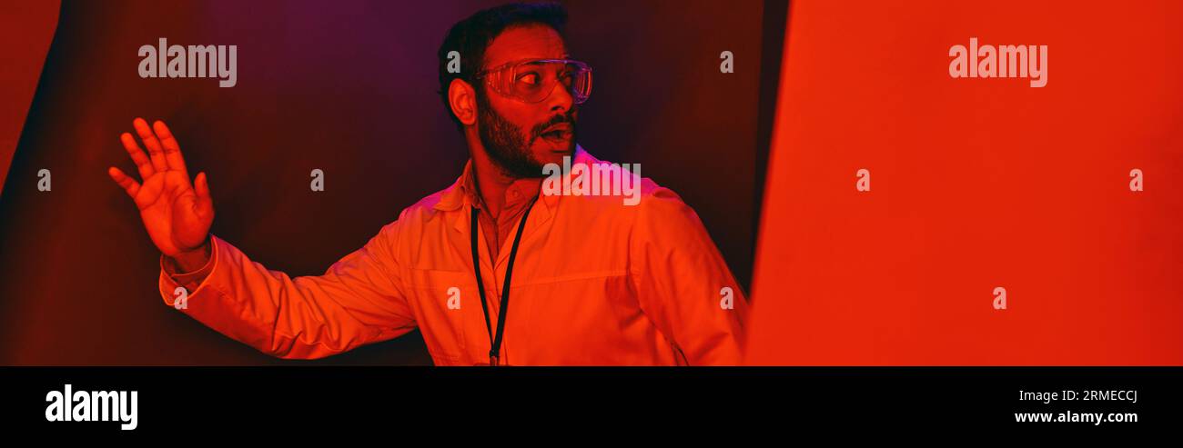 frightened indian scientist looking away in red neon light, unknown ...