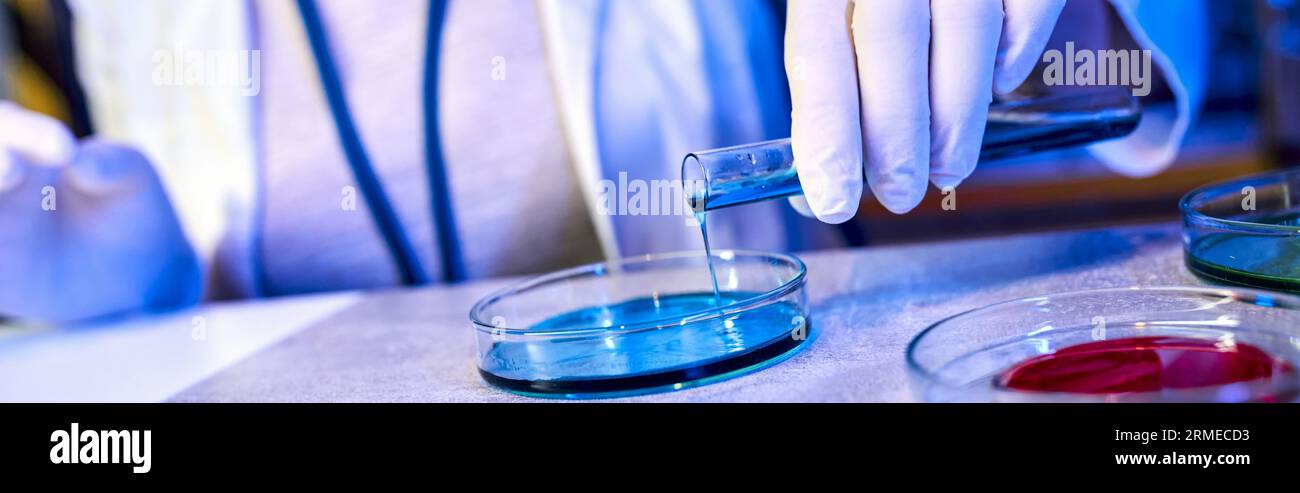 cropped view of scientist pouring liquid in petri dish, exploring alien ...