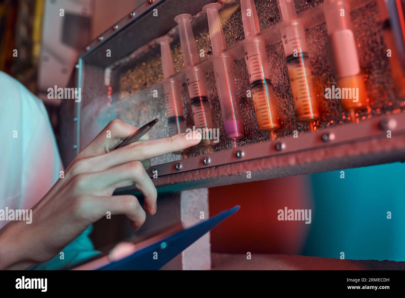 cropped view of scientist pointing at test tubes with liquid samples of ...