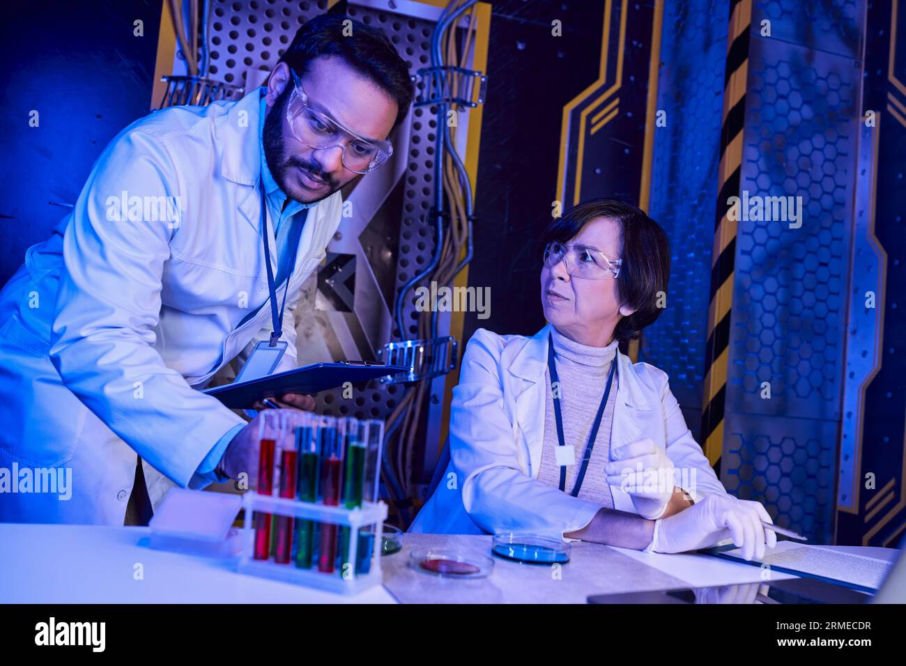 indian scientist looking at test tubes with alien life samples near ...