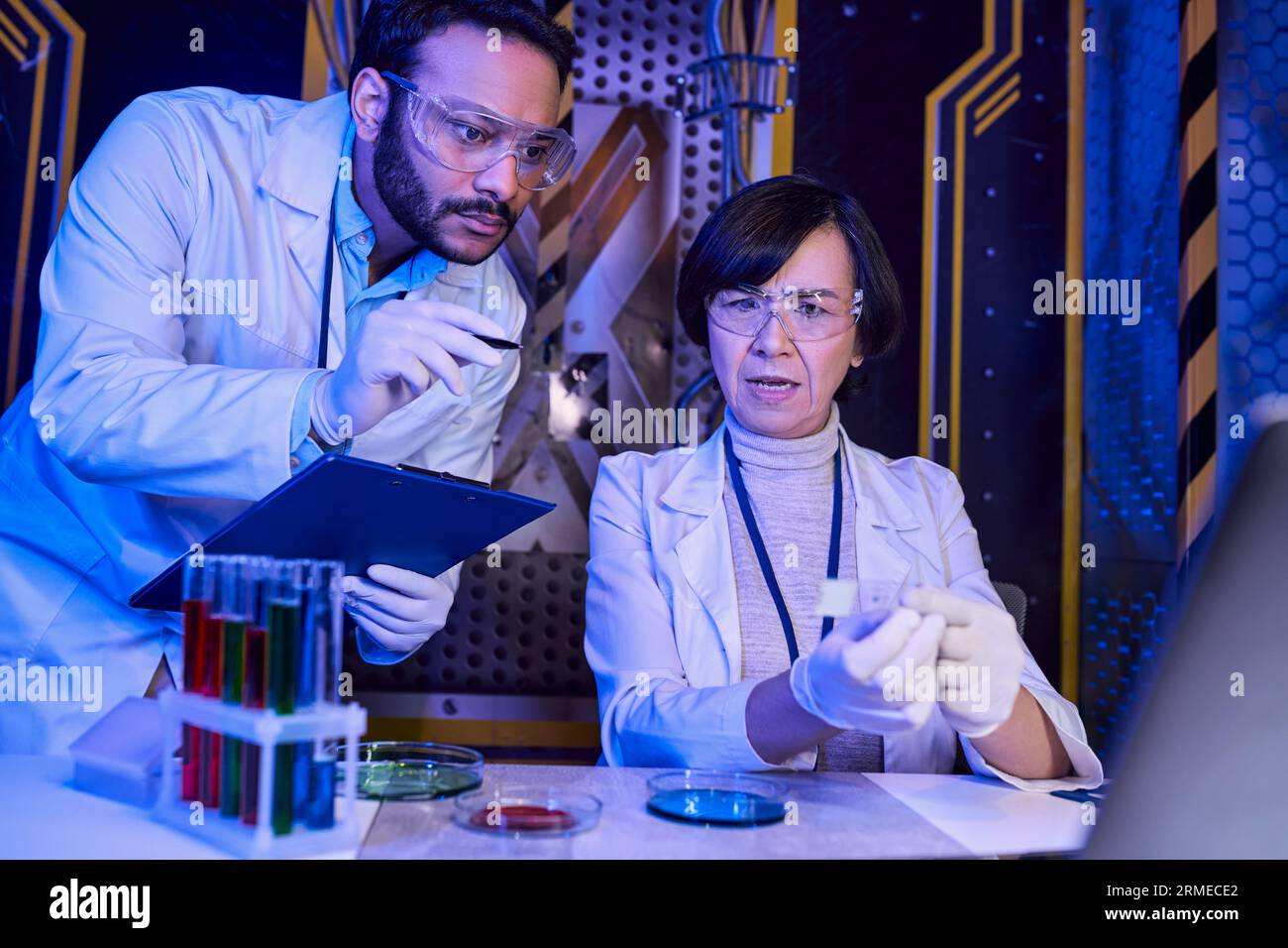 indian scientist pointing with pan at samples near colleague in ...