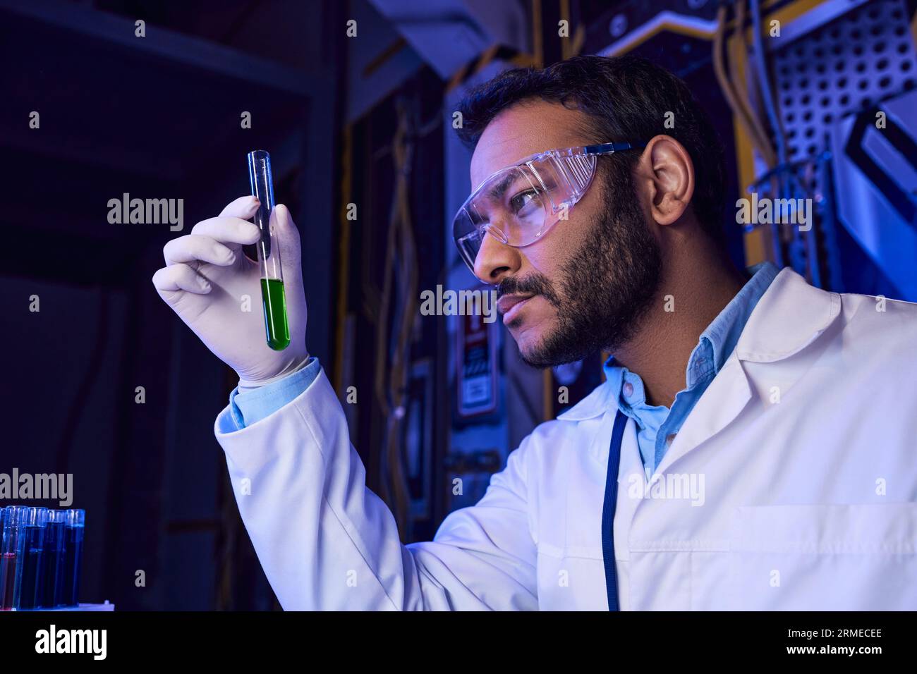 futuristic concept, indian scientist in goggles holding test tube with ...