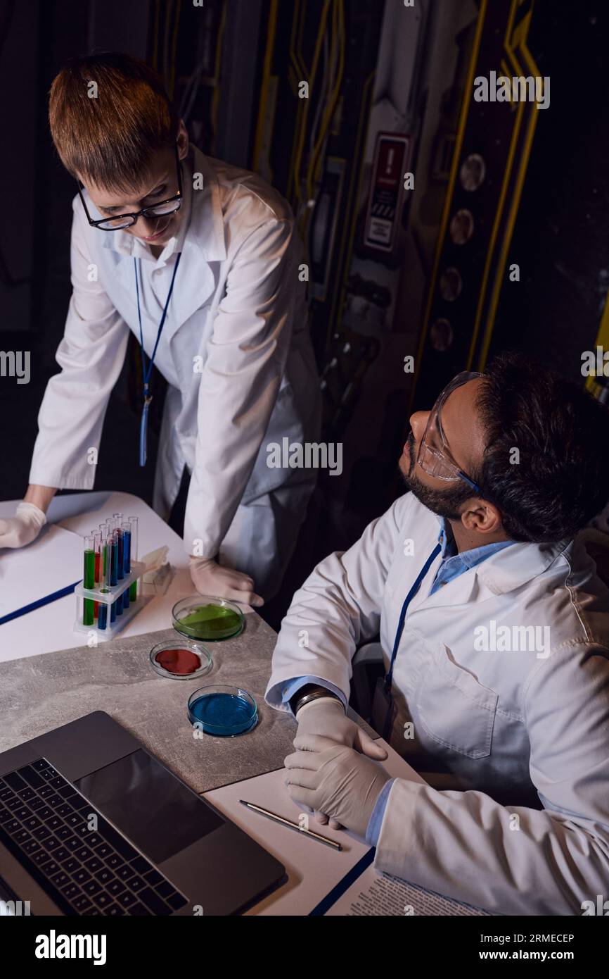 multiethnic scientists working near test tubes, petri dishes and laptop ...