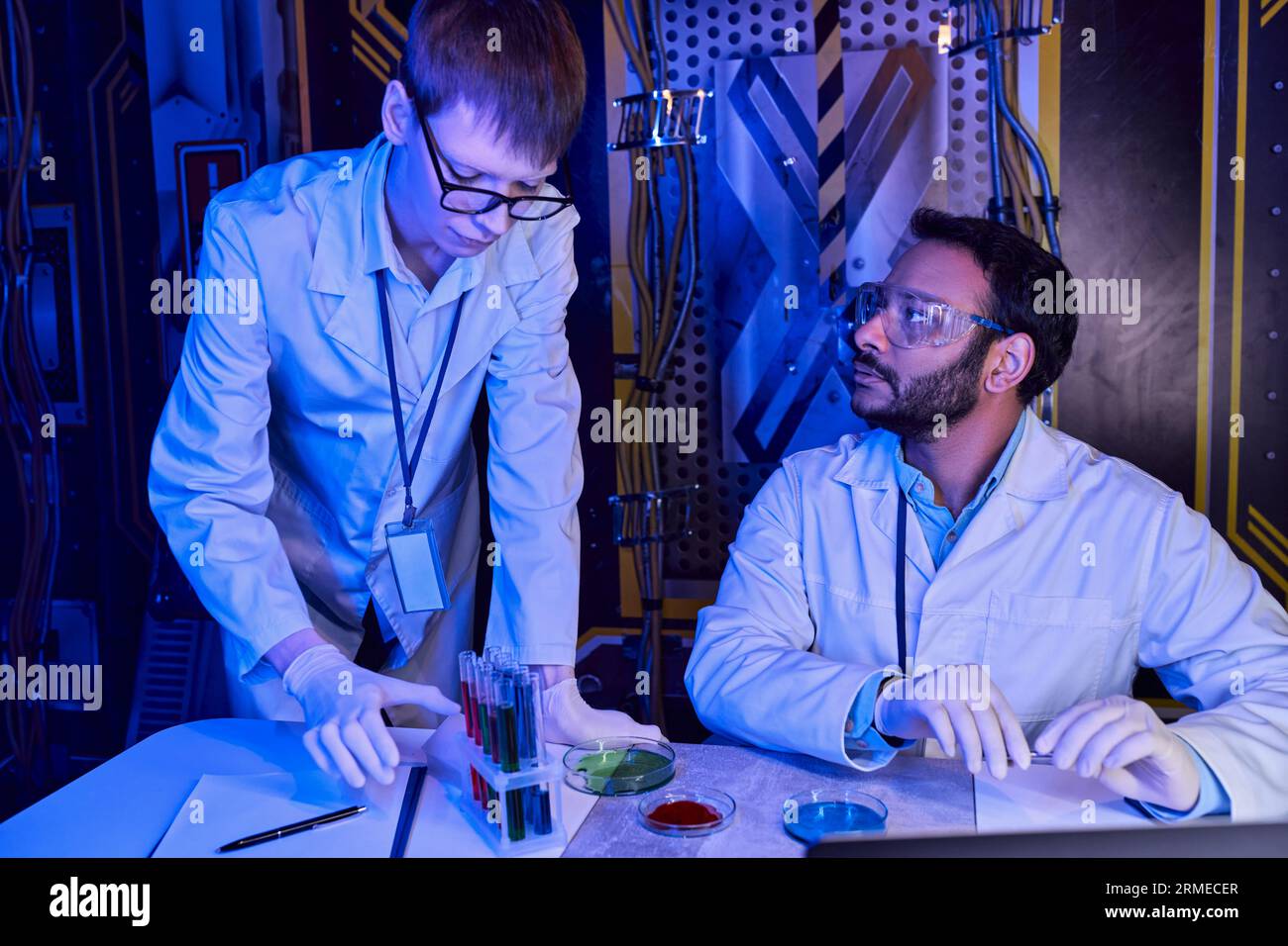 young intern near indian scientist, test tubes with petri dishes in ...