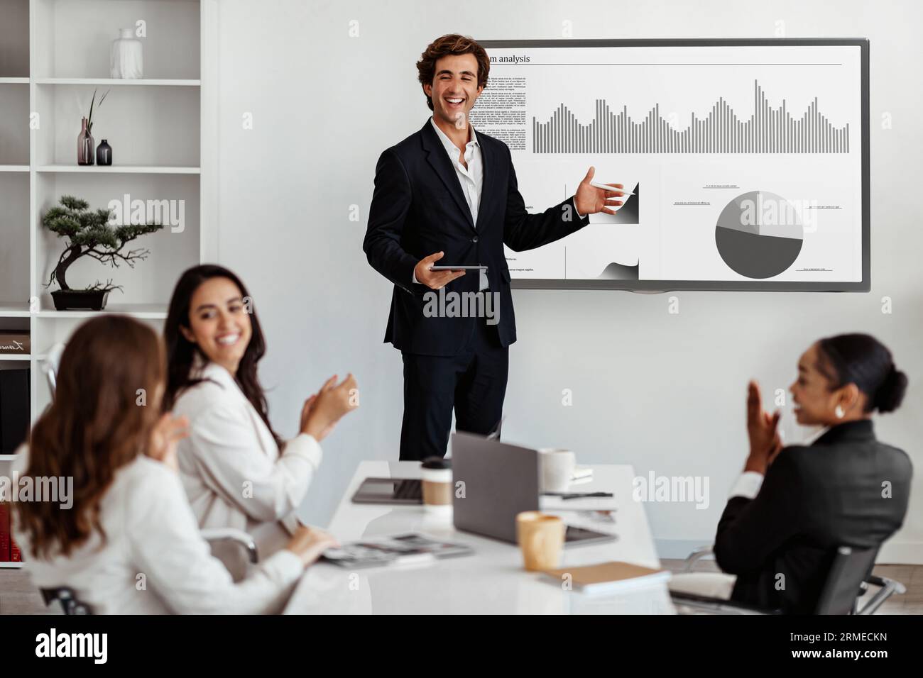 Business meeting with businessman giving statistics to multiracial ...