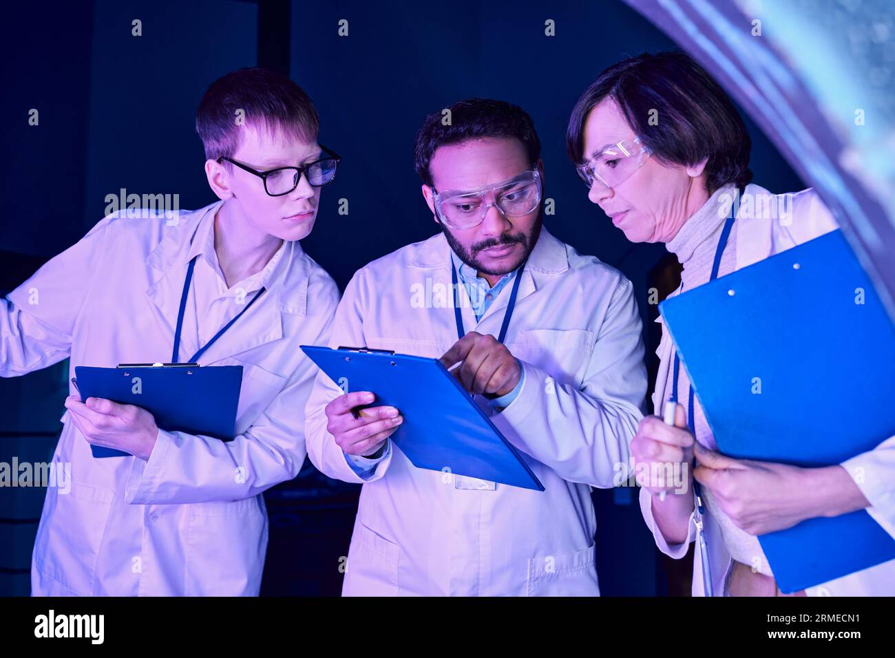 Futuristic Analysis: Scientists of Varied Ages Compare Data in Neon-Lit ...