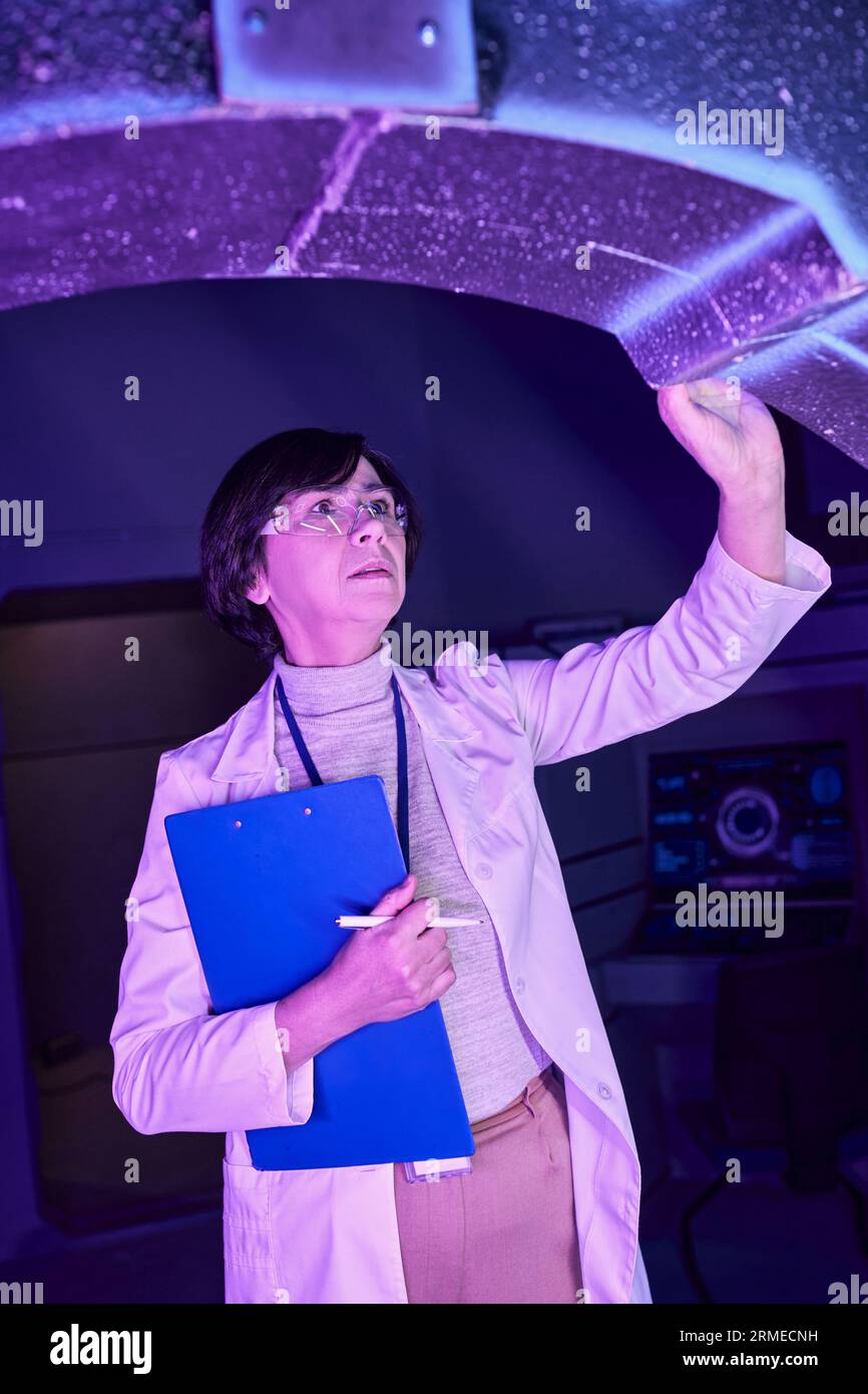 futuristic science center, female scientist with clipboard examining ...