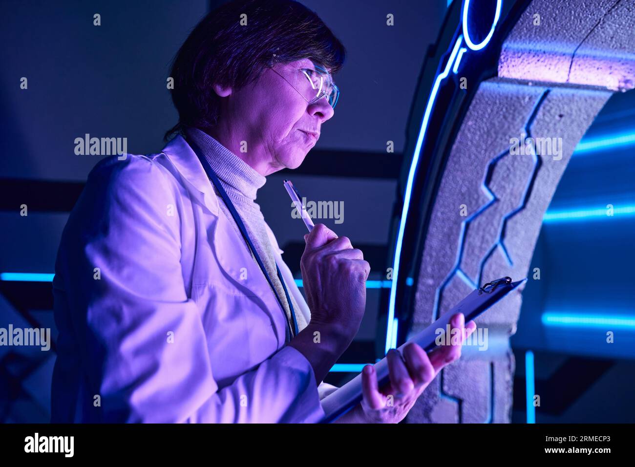 future technologies, thoughtful female scientist with pen exploring ...