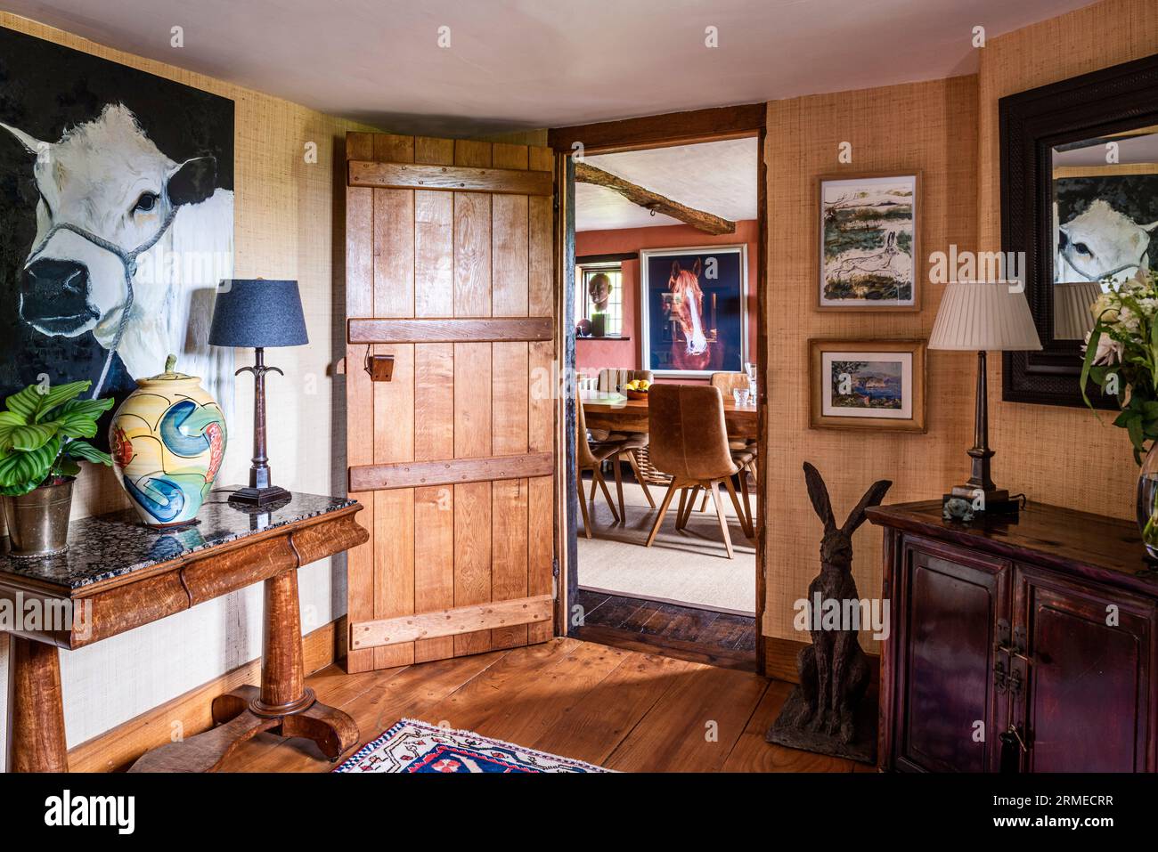 View through oak doorway to dining room in Tudor farmhouse, Surrey, UK ...