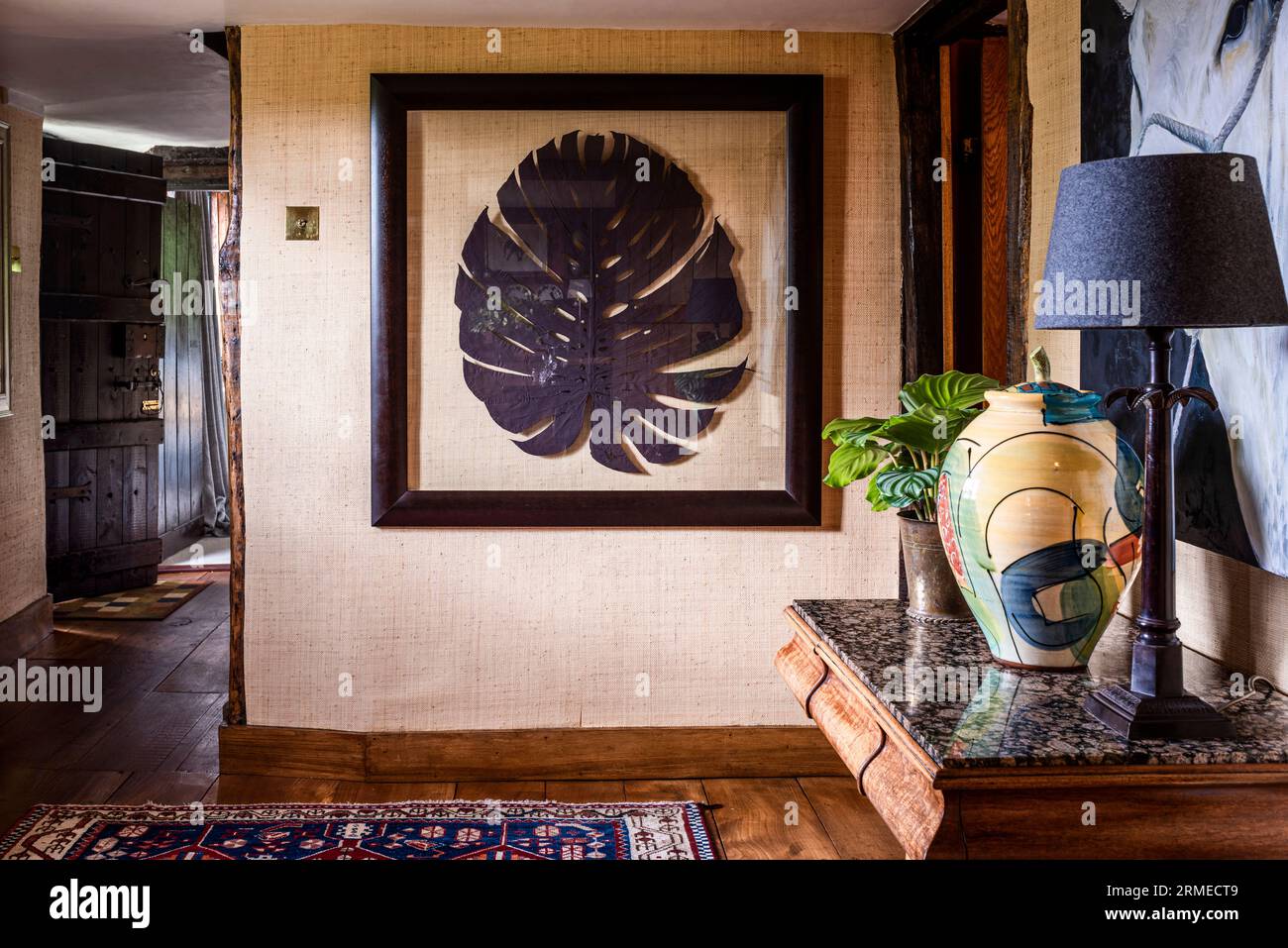 Large framed Monstera leaf in entrance hall of Tudor farmhouse, Surrey ...