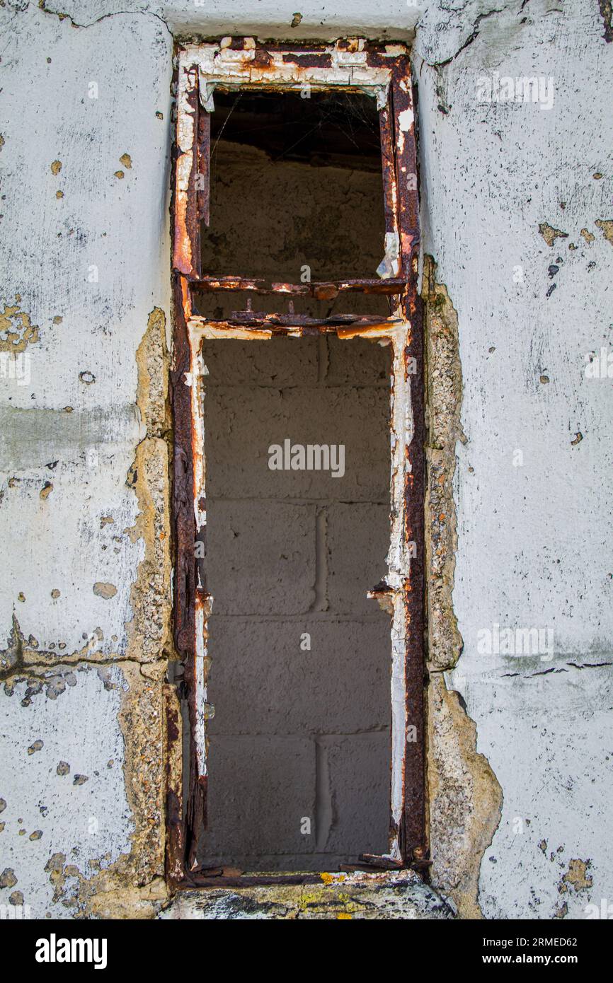 Rusting and broken metal window frame in a derelict building with ...