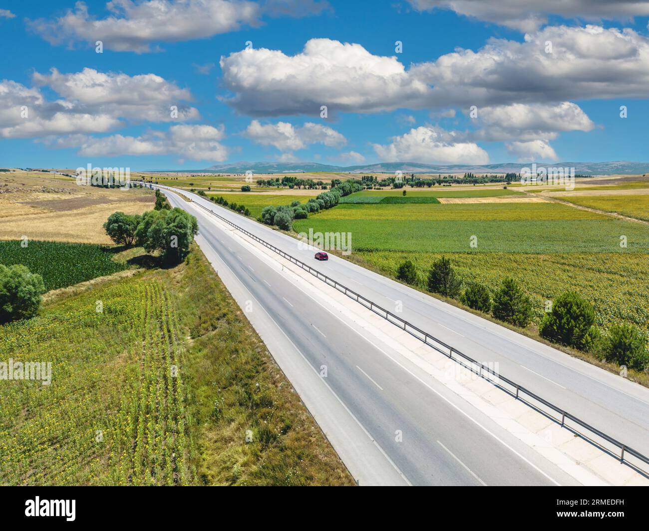 Aerial view of cars and transport trucks on Highway with fields on both ...