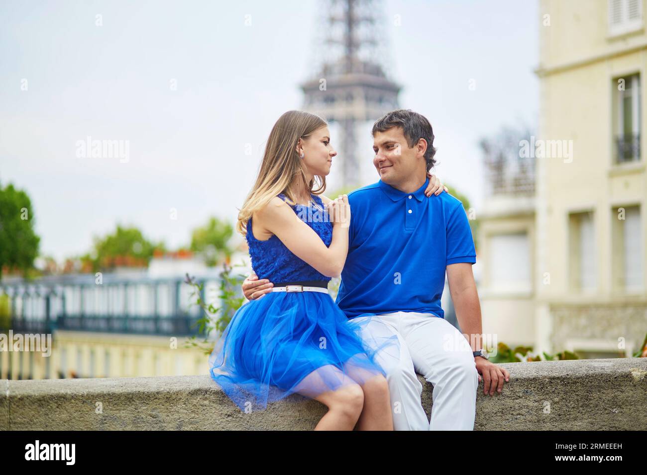 Beautiful young dating couple in Paris looking at the Eiffel tower ...
